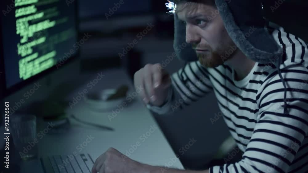 Tilt up of brutal Russian hacker in fur ear flap hat and sailor shirt ...