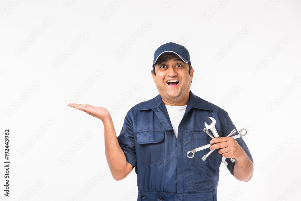 Indian happy auto mechanic in blue suit and cap holding spanner tool in ...