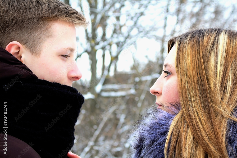 The guy stands against the young girl, they look into each other's eyes ...