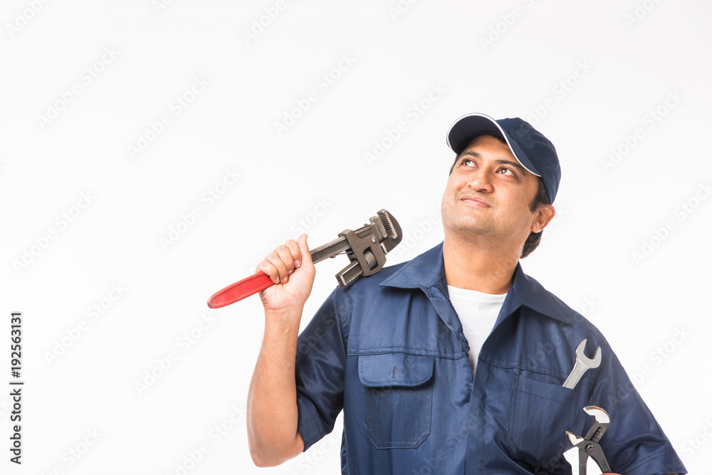 Indian plumber at work with Pipe wrench or plumbing spanner, standing ...