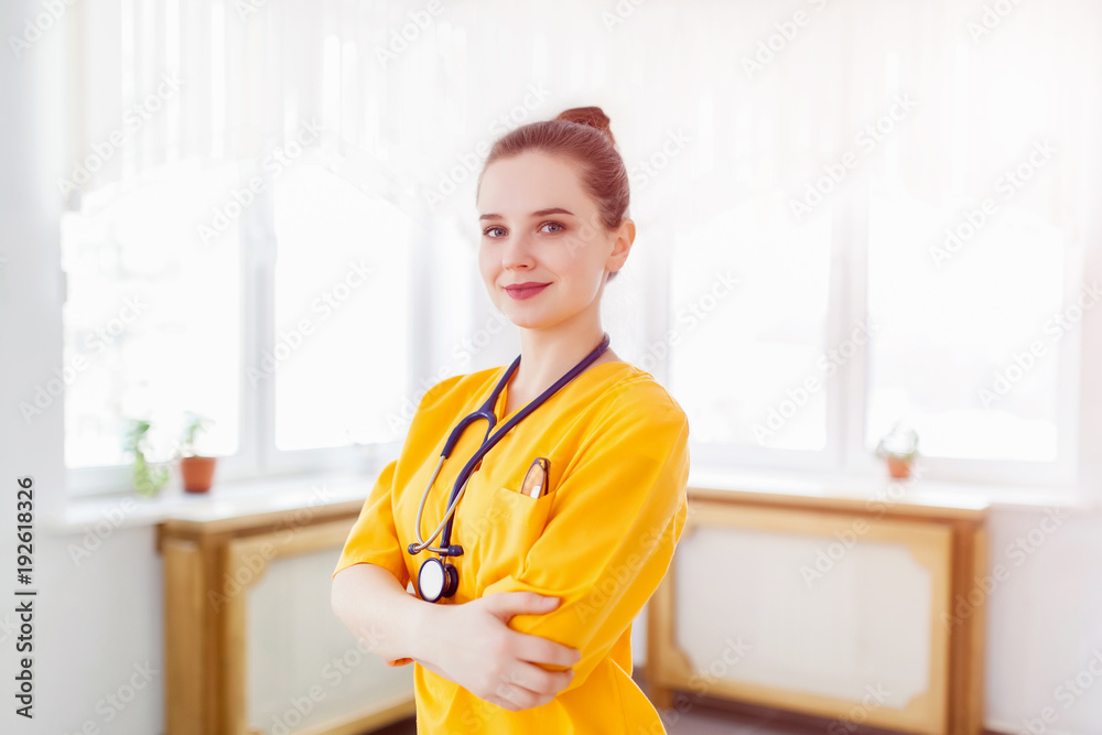 Doctor beautiful girl smiling. portrait in yellow uniform with a ...