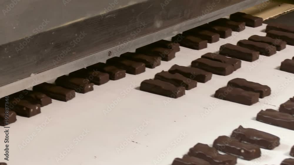 Chocolate bars move along conveyor belt at confectionery factory for ...