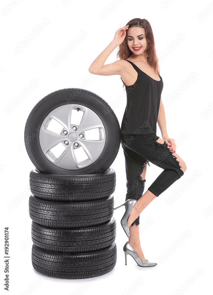 Young woman in seductive outfit with car tires on white background ...