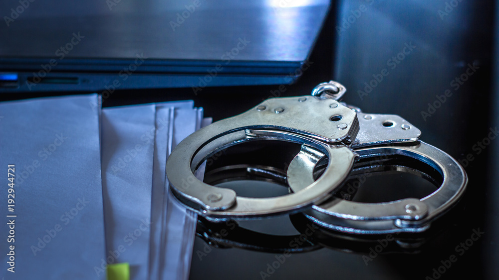 Handcuffs on the desk with laptop,cyber crime concept Stock Photo ...