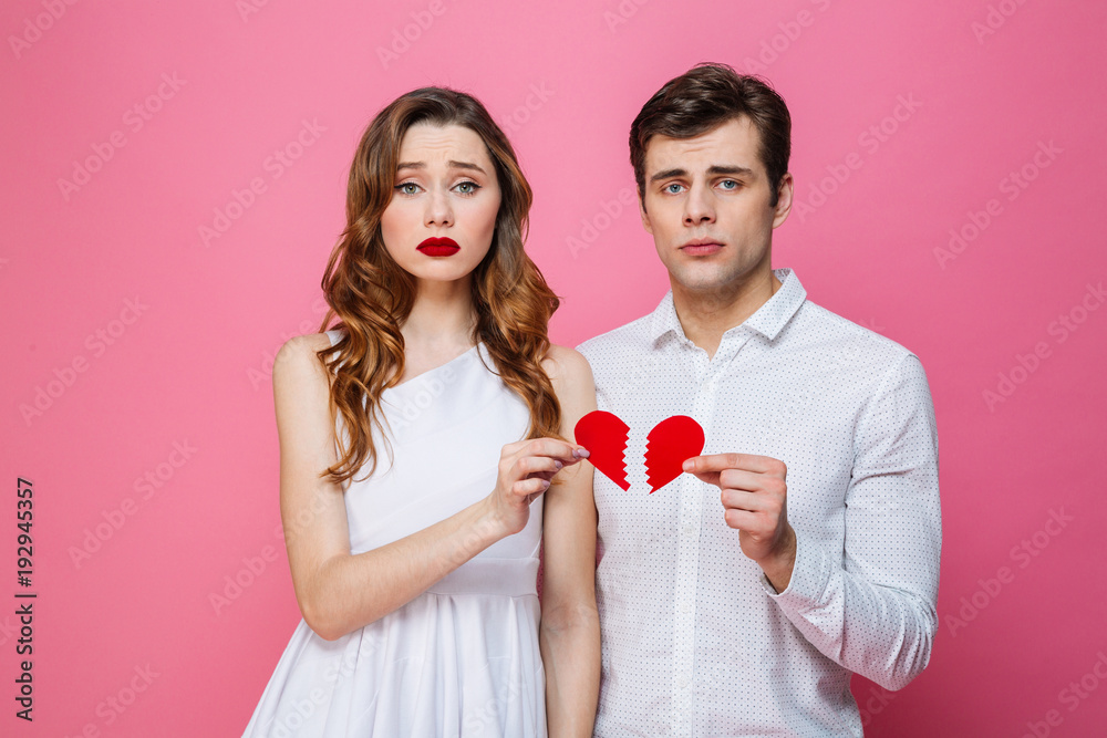 Sad loving couple holding broken heart Stock Photo | Adobe Stock
