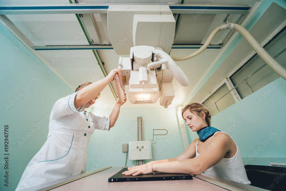 Radiologist and patient in a x-ray room. Classic ceiling-mounted x-ray ...