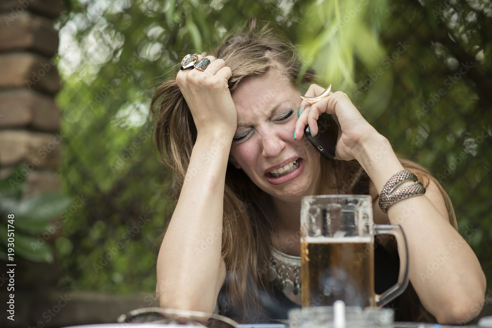 Heart broken girl crying over her cellphone, drunk, drinking a beer in a bar Stock Photo | Adobe ...