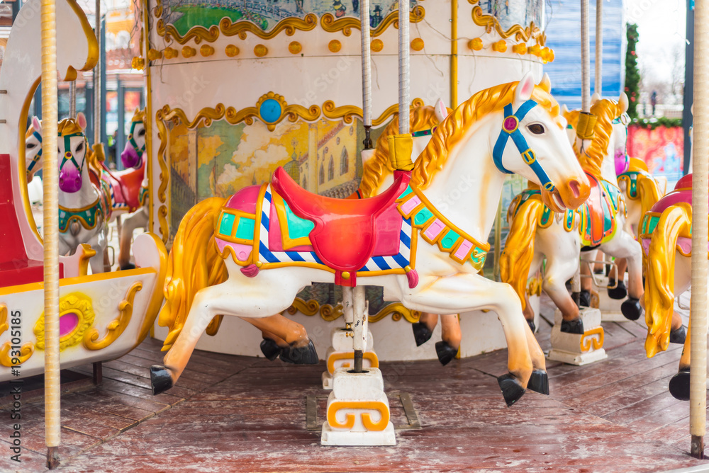 Old French carousel in a holiday park. Three horses and airplane on a ...