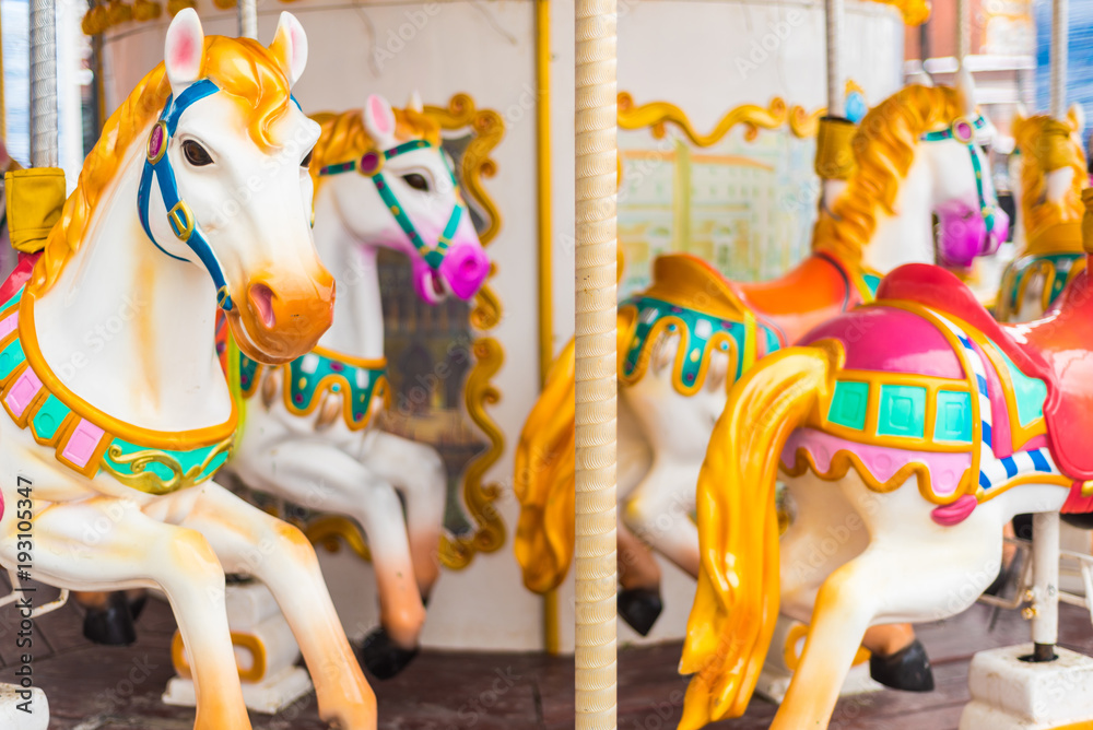 Old French carousel in a holiday park. Three horses and airplane on a ...