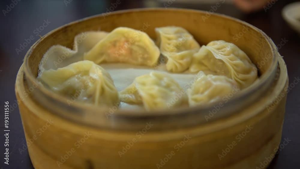 4K Using chopsticks for eating dumplings in a restaurant. Traditional ...