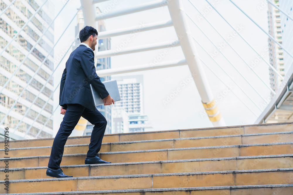 Business man celebrating success. Young businessman walking at stairs ...