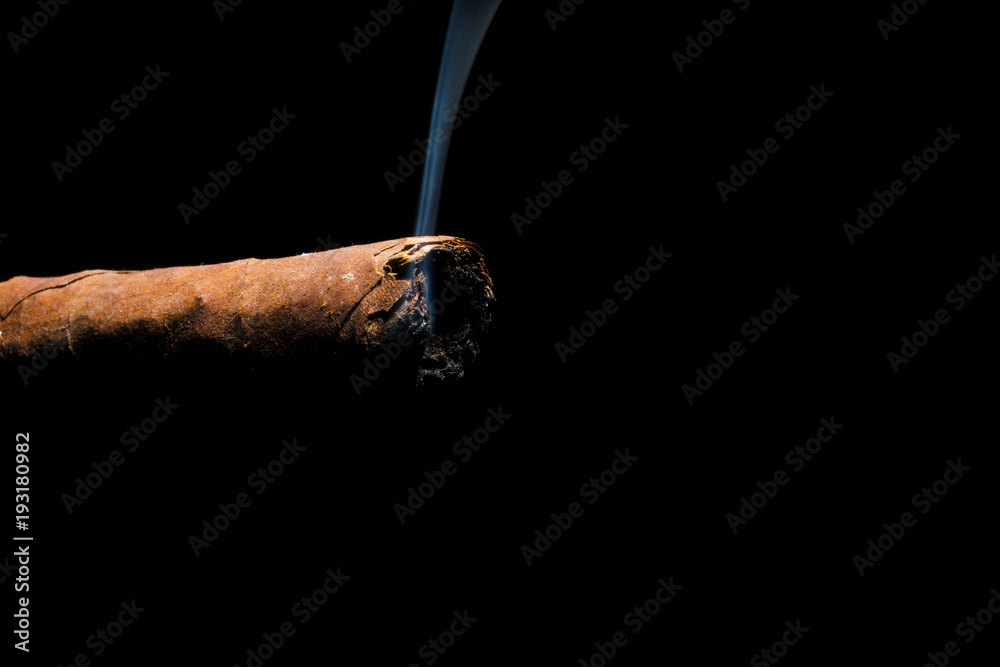 Cigar burnt with smoke on the tip on a black background Stock Photo ...