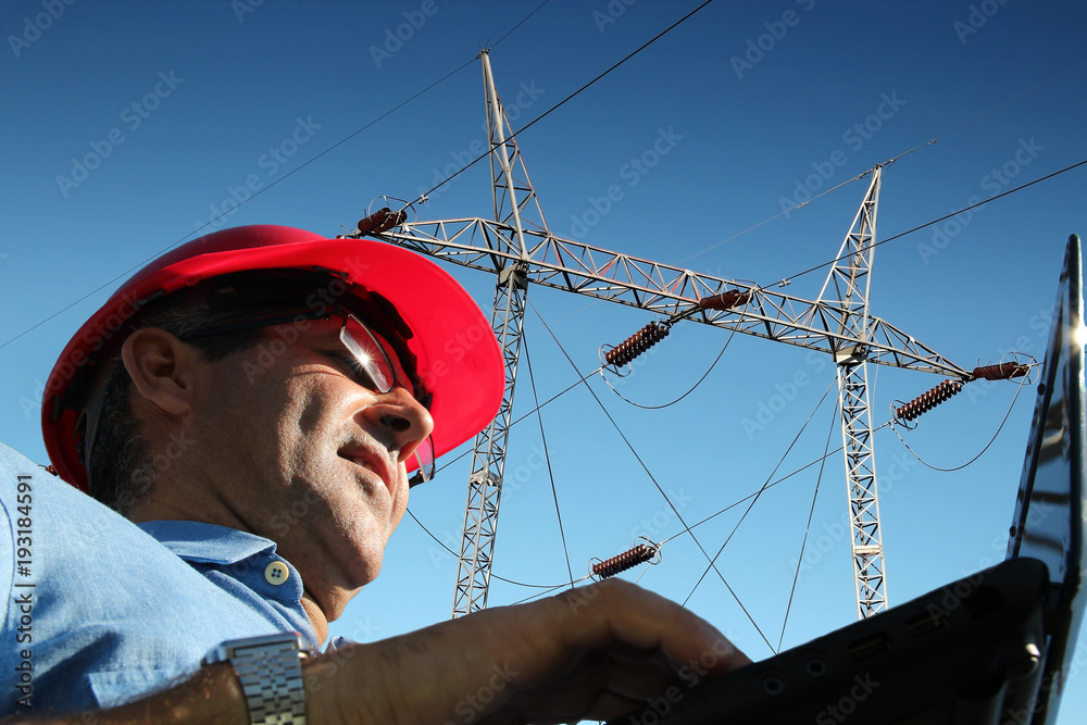 Engineer With Laptop Computer Under the Power Lines / Engineer with red ...