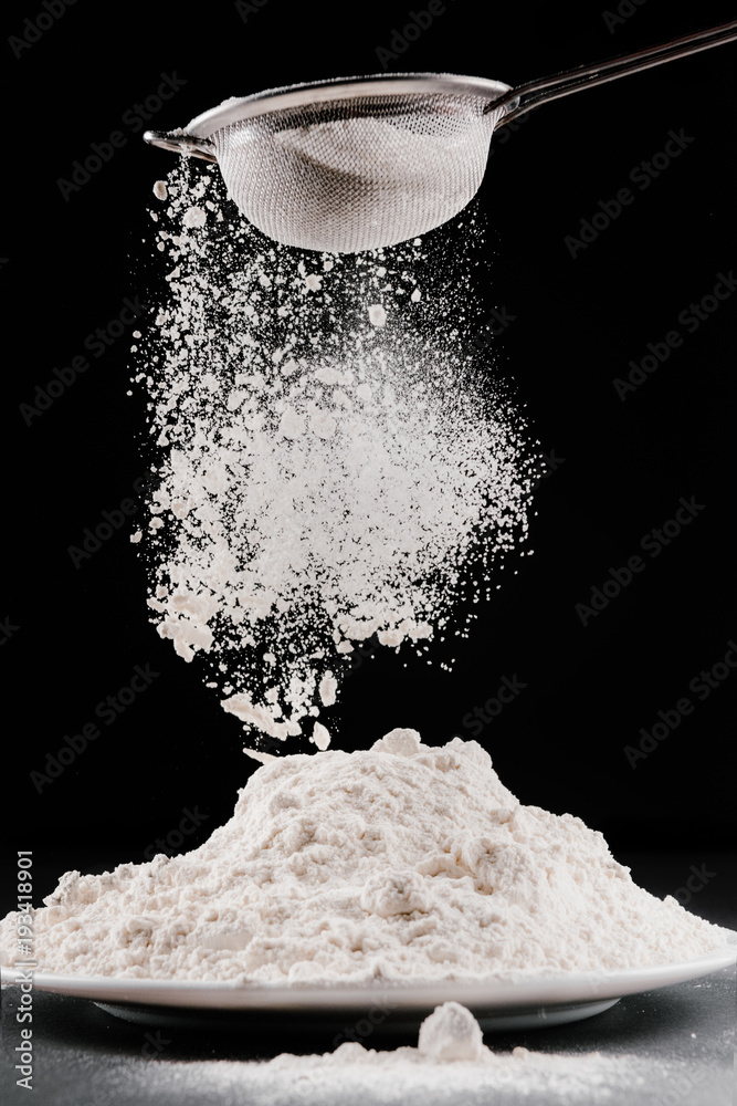 flour falling from sieve on pile isolated on black Stock Photo | Adobe ...