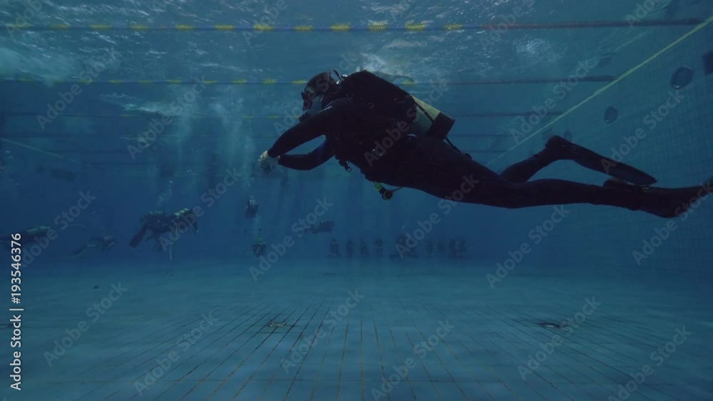 Scuba diver floating underwater in swimming pool. Learning scuba diving ...