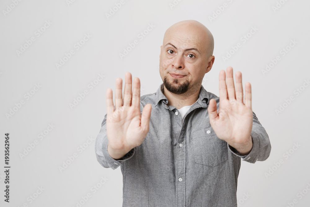 Body language. Disgusted serious angry bald man with beard in grey ...
