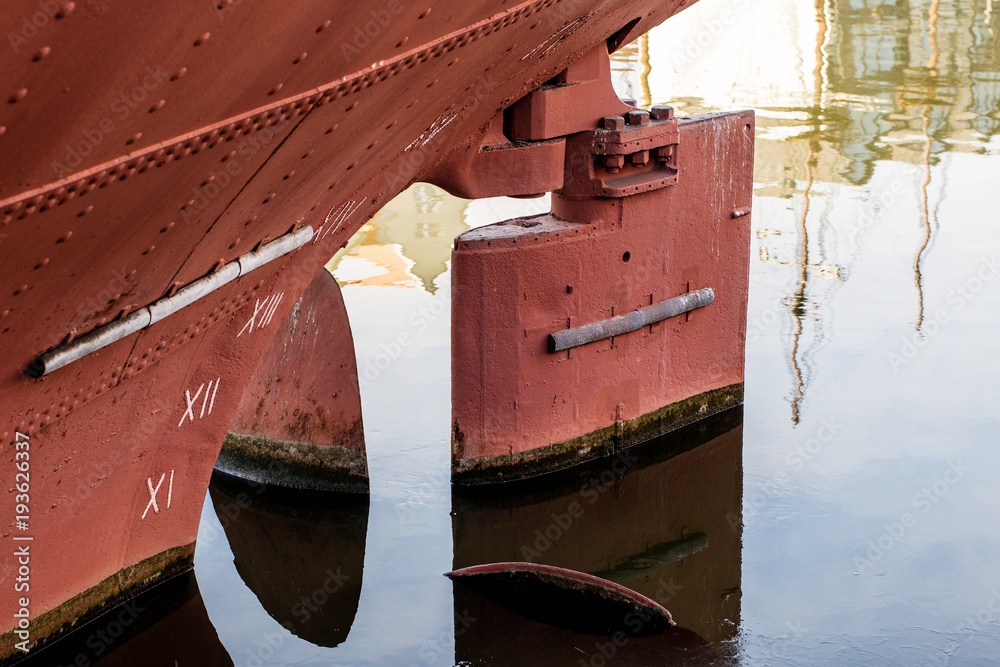 Rudder of an old commercial ship. Rudder seen from the wharf of the ...