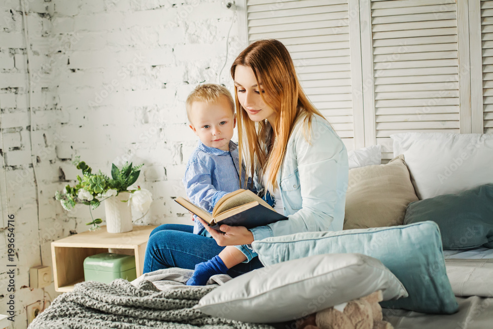 Cute Mother Reading a Book to her Son at Home. Mom and Child Reading ...