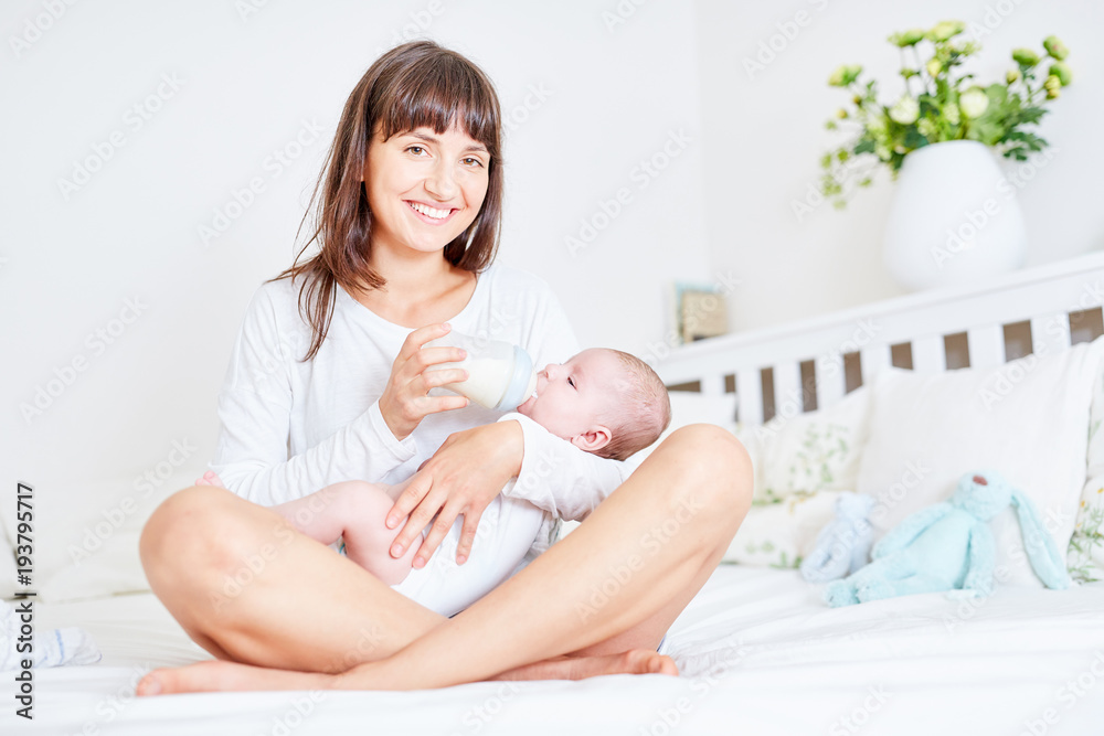 Glücklich lächelnde Mutter füttert ihr Baby Stock-Foto | Adobe Stock