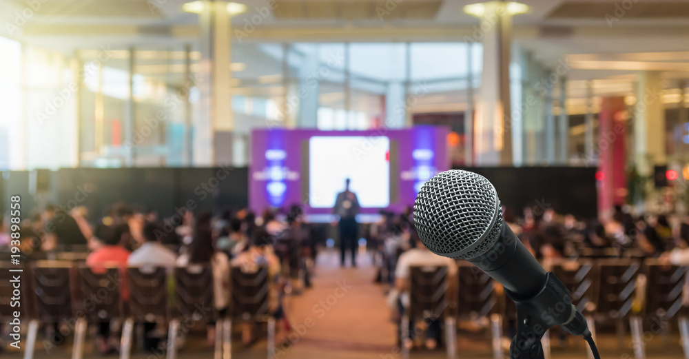 Microphone over the Abstract blurred photo of conference hall or ...
