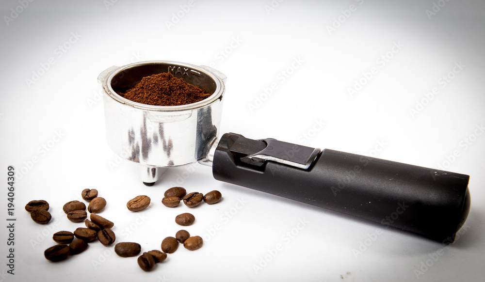 Espresso coffee filter with tamped grounds ready to be inserted into ...
