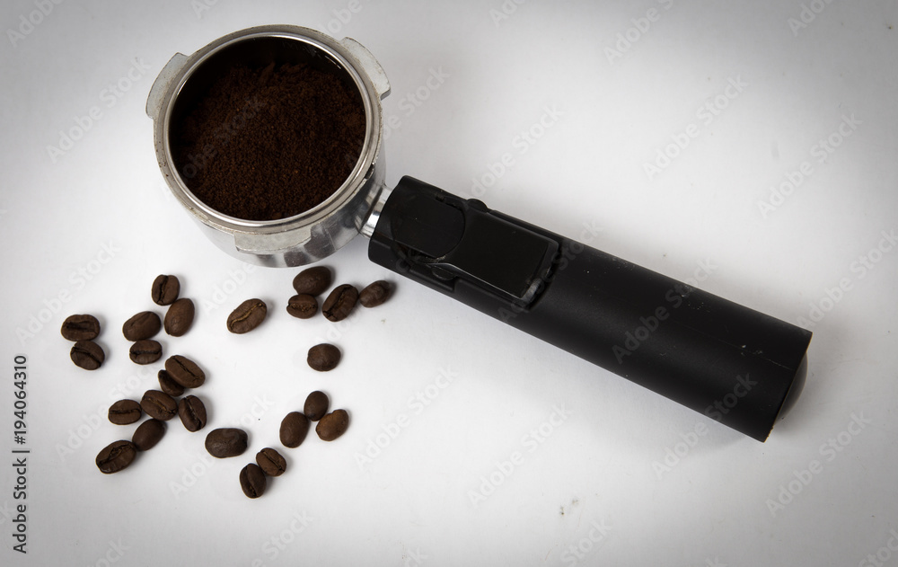 Espresso coffee filter with tamped grounds ready to be inserted into ...