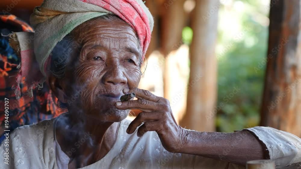 Old lady of Pa'O ethnic minority smoking a Burmese cigar at Indein ...