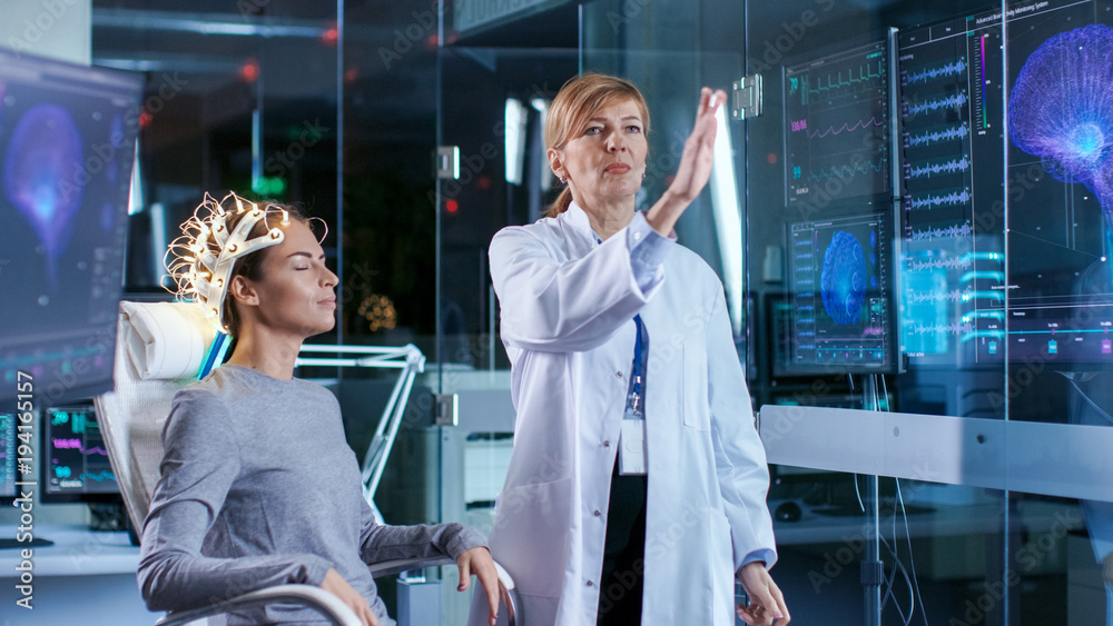 Woman Wearing Brainwave Scanning Headset Sits in a Chair while ...