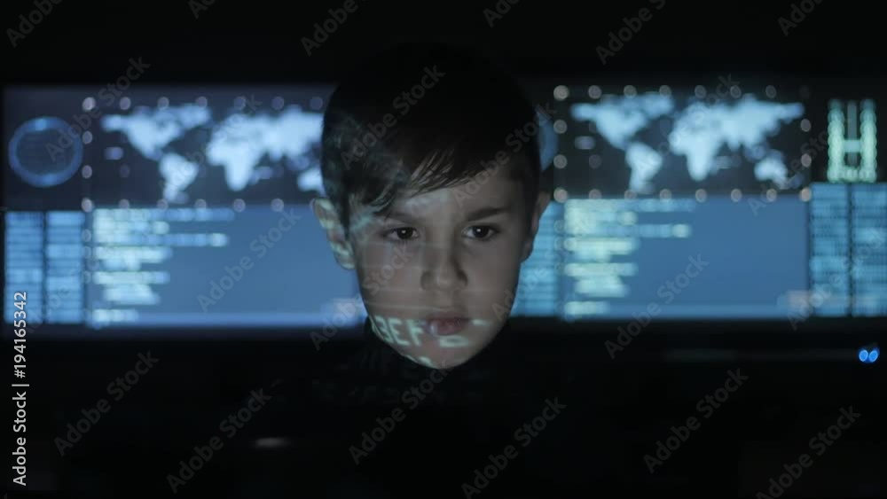 young prodigy boy hacker programmer working at the computer in the data ...