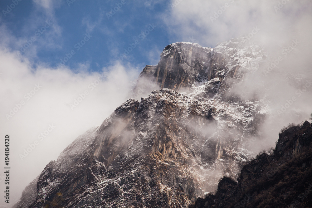 Himalaya cliff peal in fog. View of himalayan peaks in fog from ...