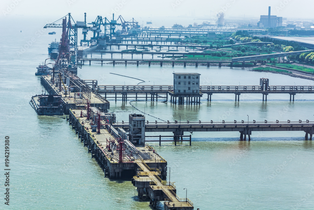 Crude oil tanker under cargo operations on typical shore station with ...