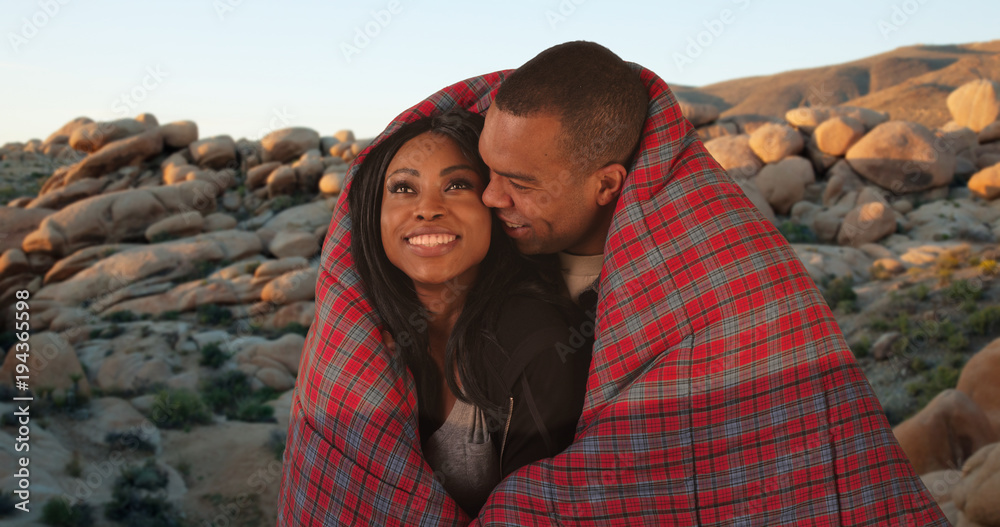Black couple wrapped up in sleeping bag while camping in Joshua Tree ...