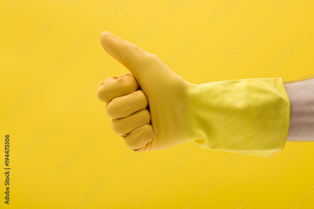 Thumbs up hand gesture made by a hand in a yellow rubber cleaning glove ...