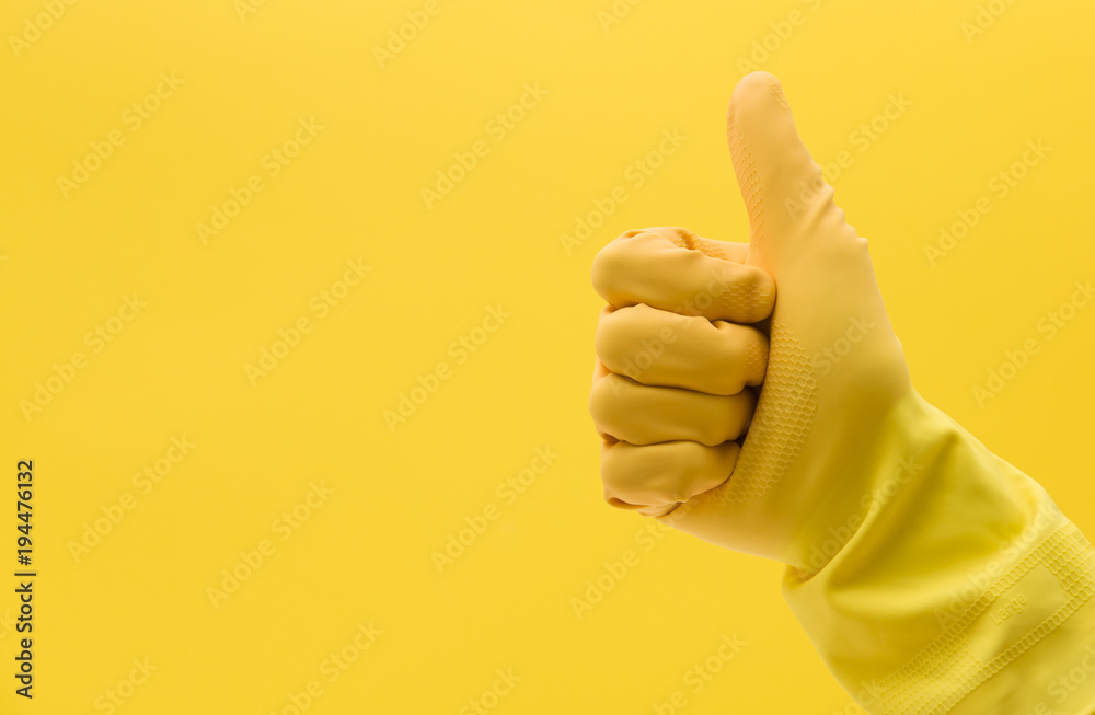 Thumbs up hand gesture made by a hand in a yellow rubber cleaning glove ...
