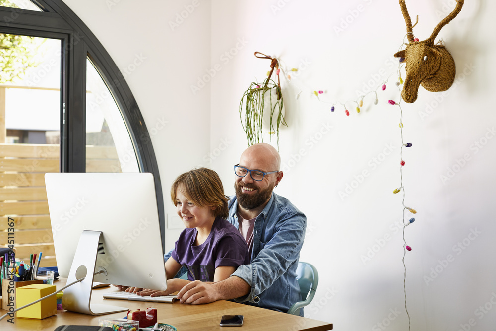 Happy Man With Son Using Computer At Table Stock Photo | Adobe Stock