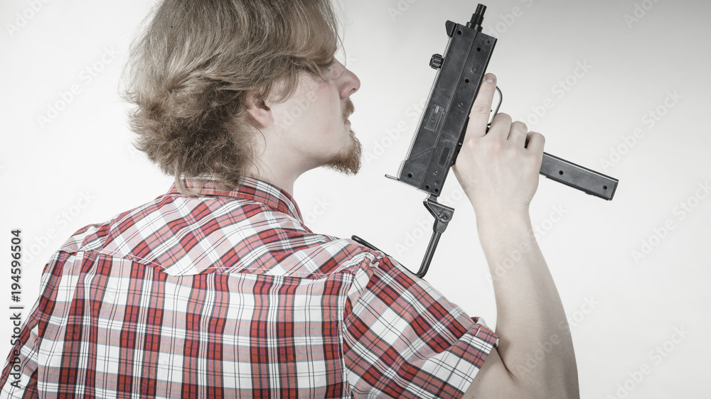 Man standing backwards holding gun Stock Photo | Adobe Stock