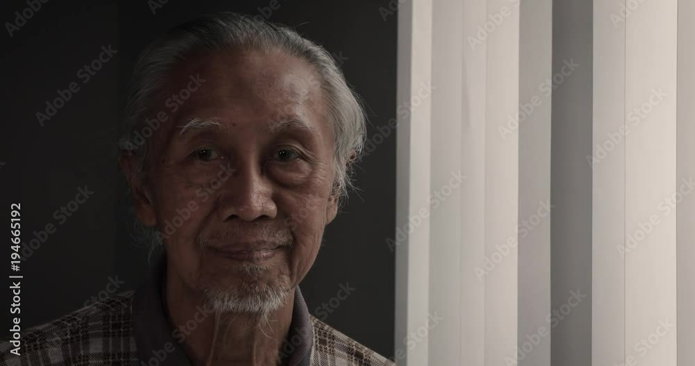 Lonely old man with grizzled hair and wrinkled skin, smiling at the ...