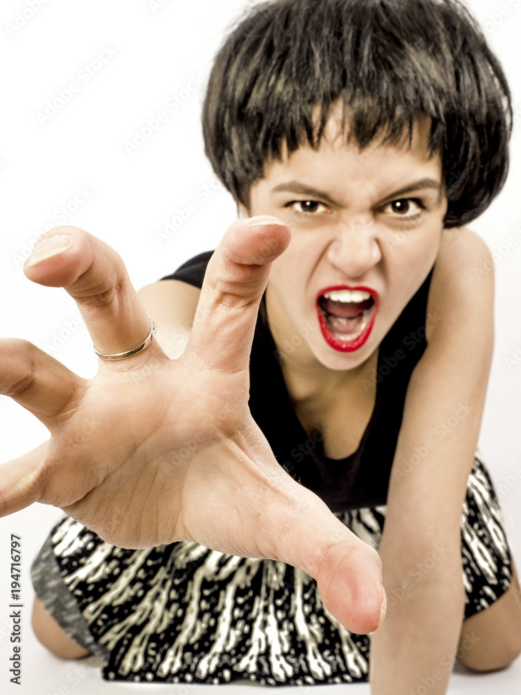 Portrait of an angry young brunette girl. Studio shooting on a light ...