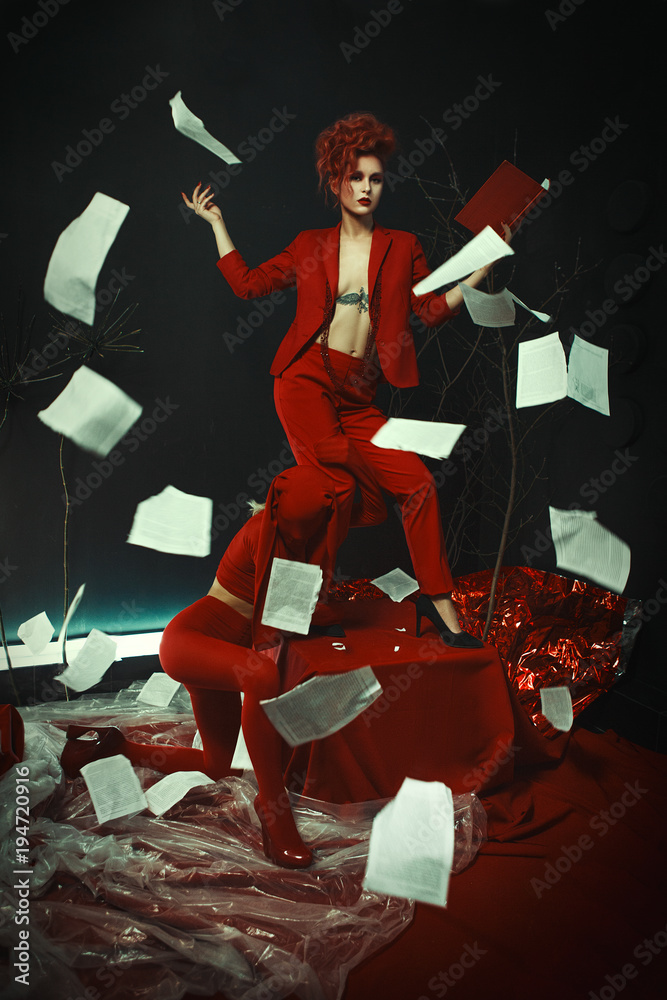 Beautiful model wearing red is posing in a dark surreal studio Stock ...