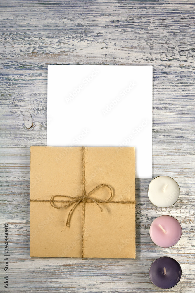 blank white greeting card and envelope with candles over rustic table ...