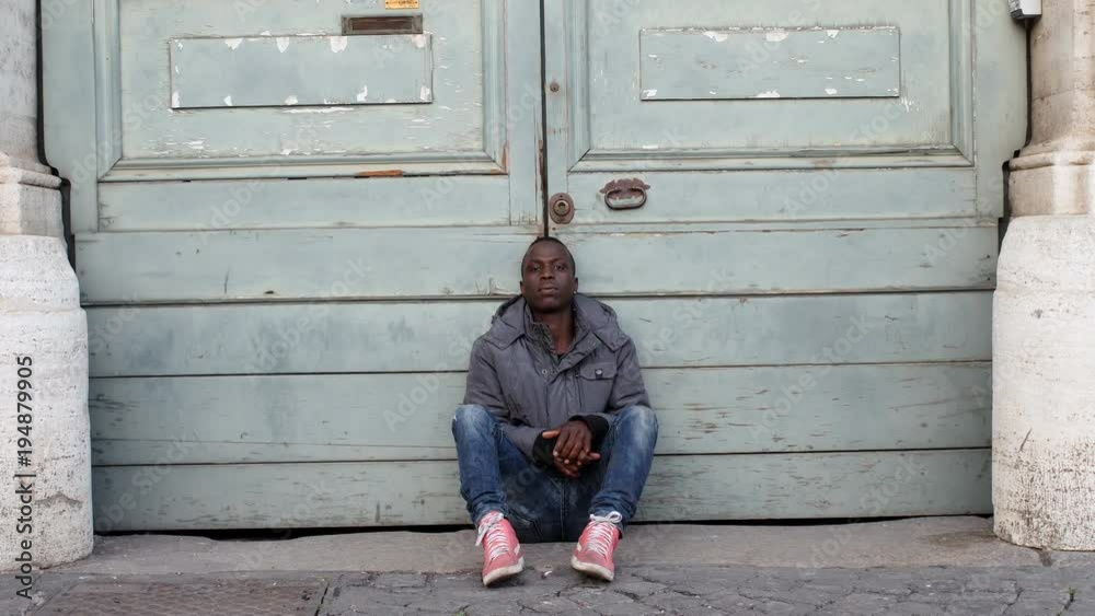 sad and depressed young African migrant sitting in the ground Stock ビデオ ...