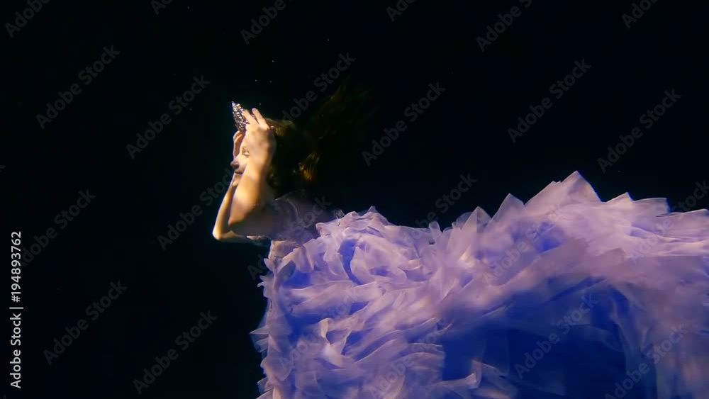 pretty cute girlie is floating under water in night dark river, wearing ...