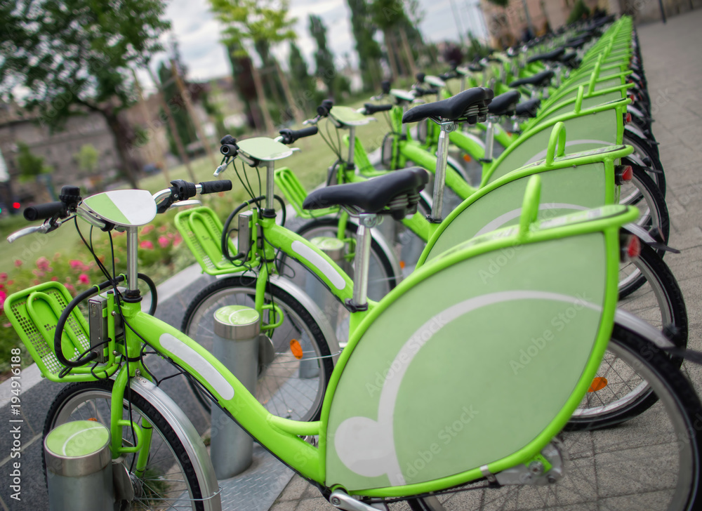 Row of new green public sharing bicycle lined up on the street , Modern ...