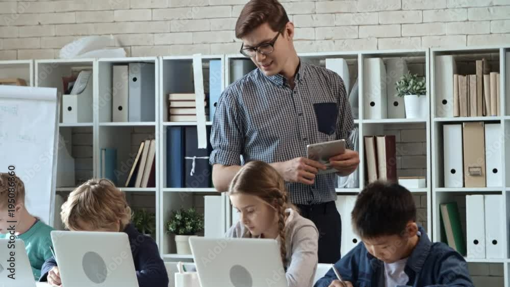 Four primary school children doing written task during information ...
