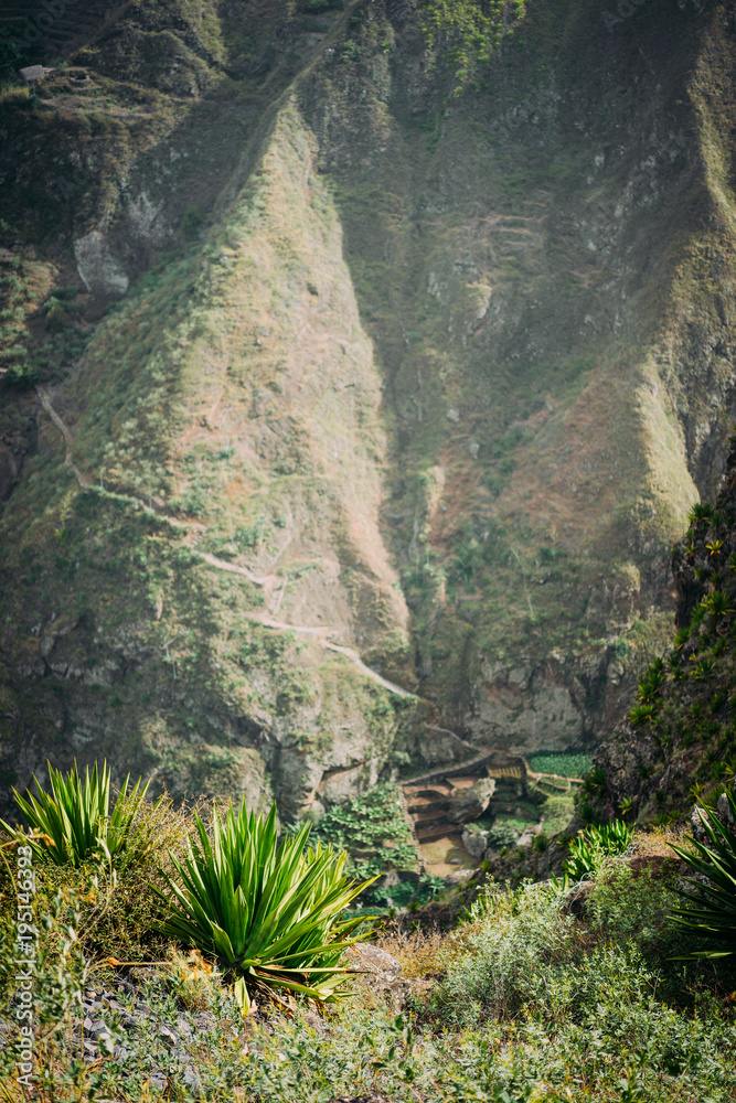 Incredible view of the steep mountain and path to green ravine. Huge ...