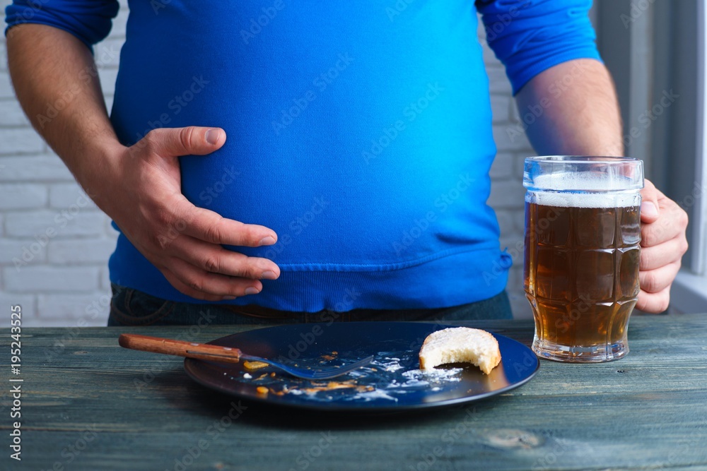Overweight man with obese belly overeating and drinking beer ...