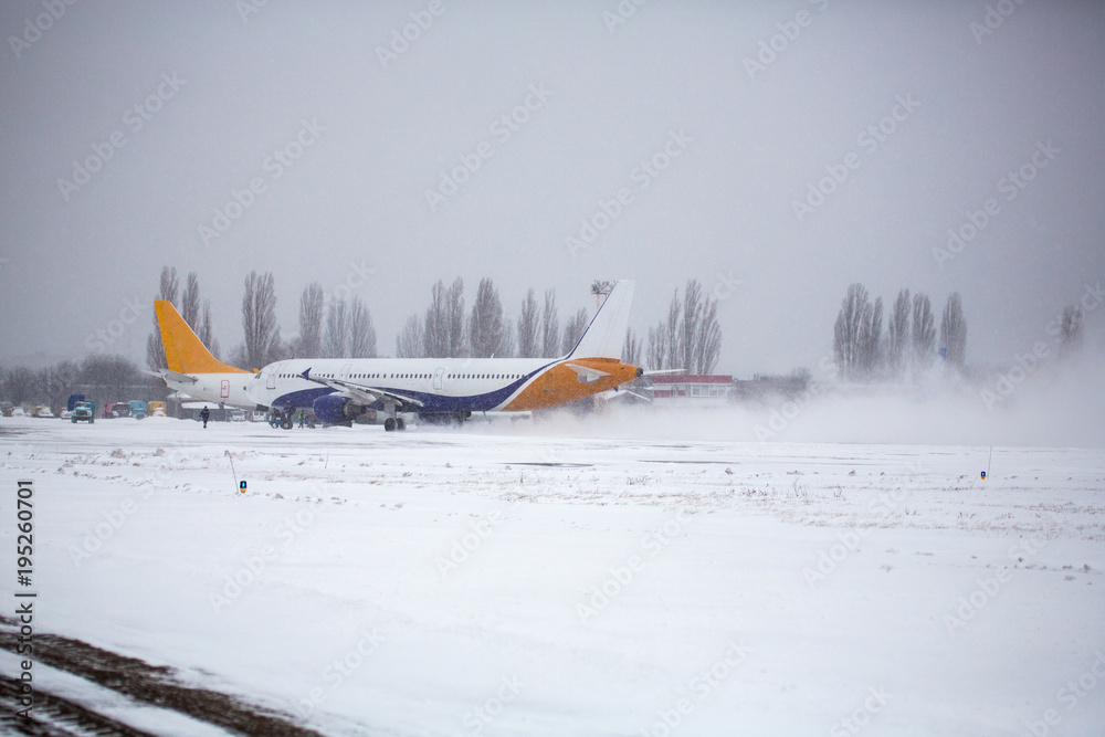 Airliner on runway in blizzard. Aircraft during taxiing at heavy snow ...