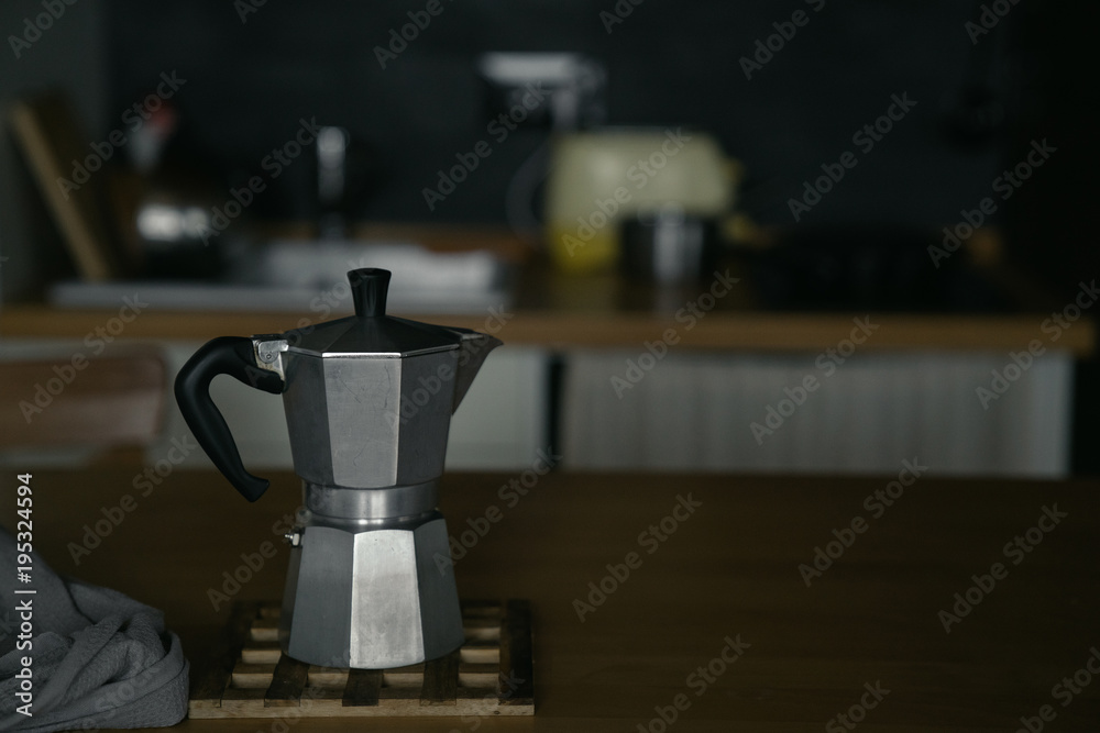 Aluminum traditional coffee maker on the table in the interior of the ...