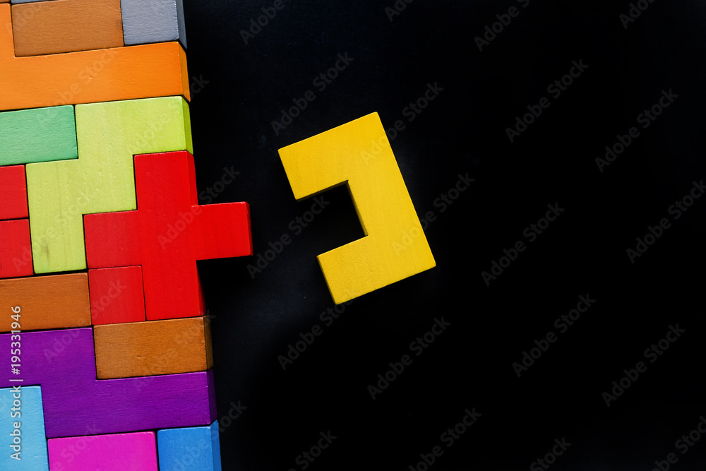 Different colorful shapes wooden blocks on black background, flat lay ...