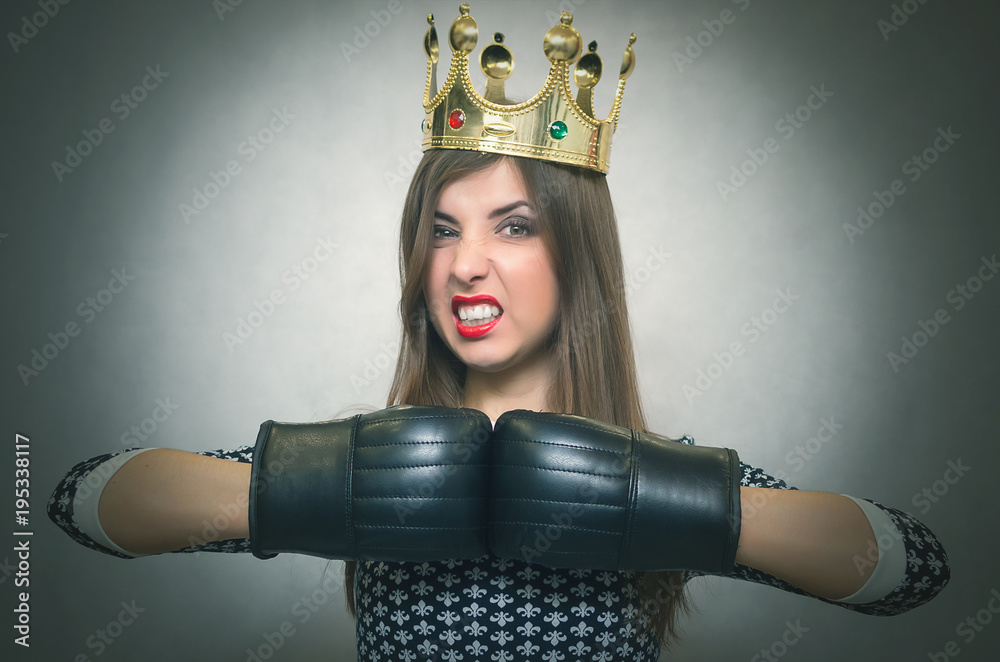 Angry confident woman with gold crown on her head and in a boxing ...